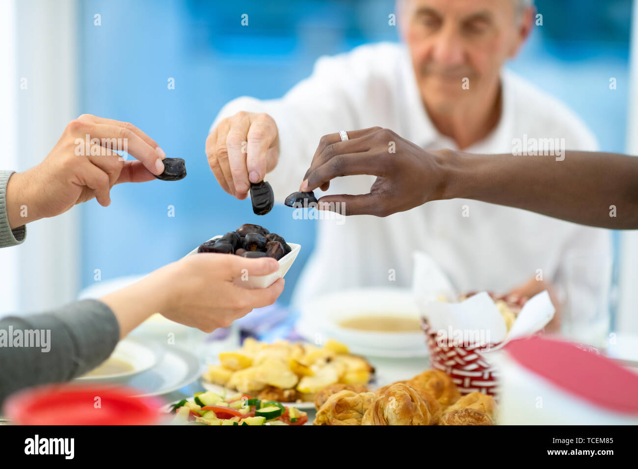 modern multiethnic muslim family sharing a bowl of dates while enjoying ...