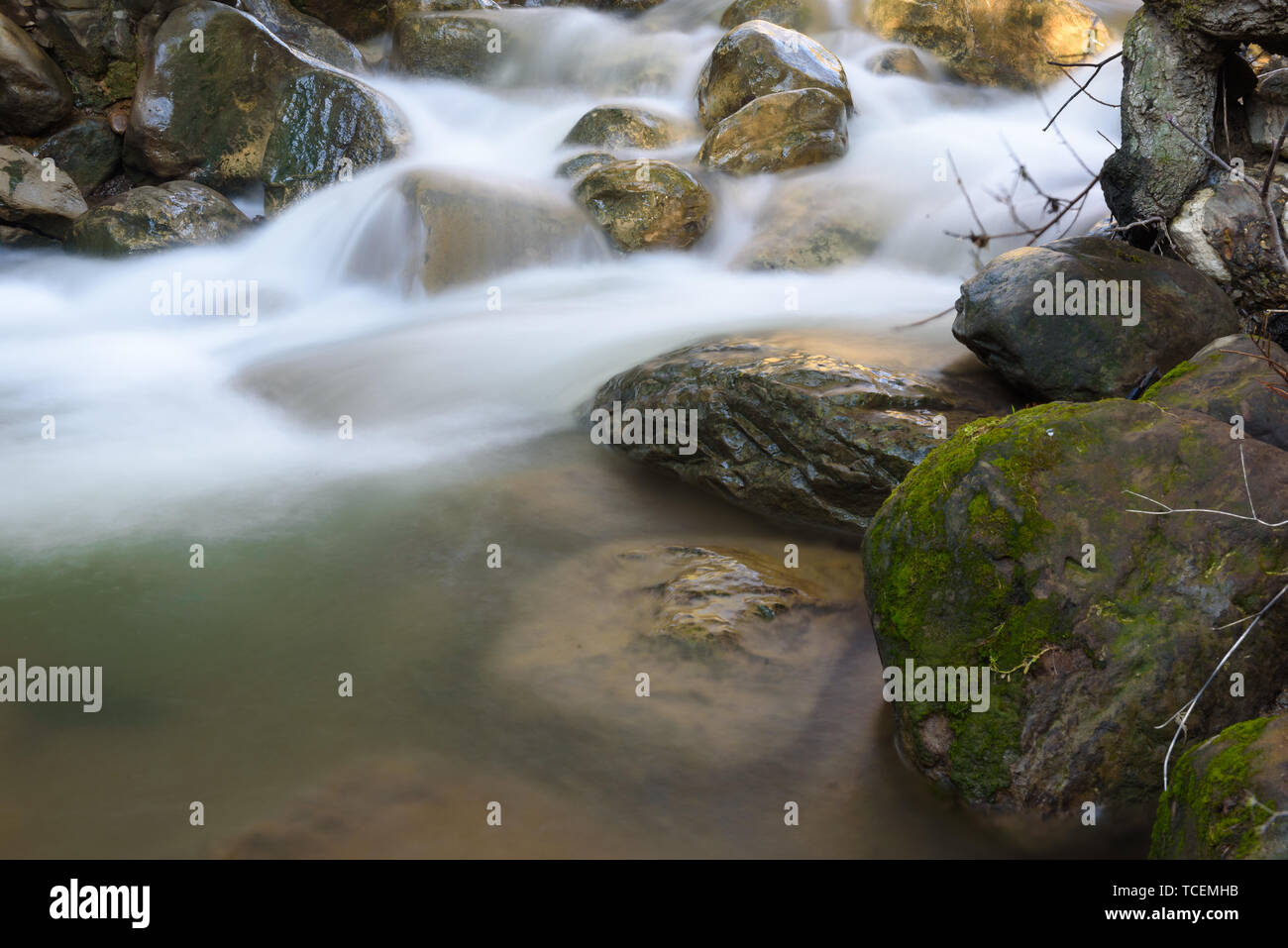 Fast moving water flowing over sand and rocks Stock Photo - Alamy