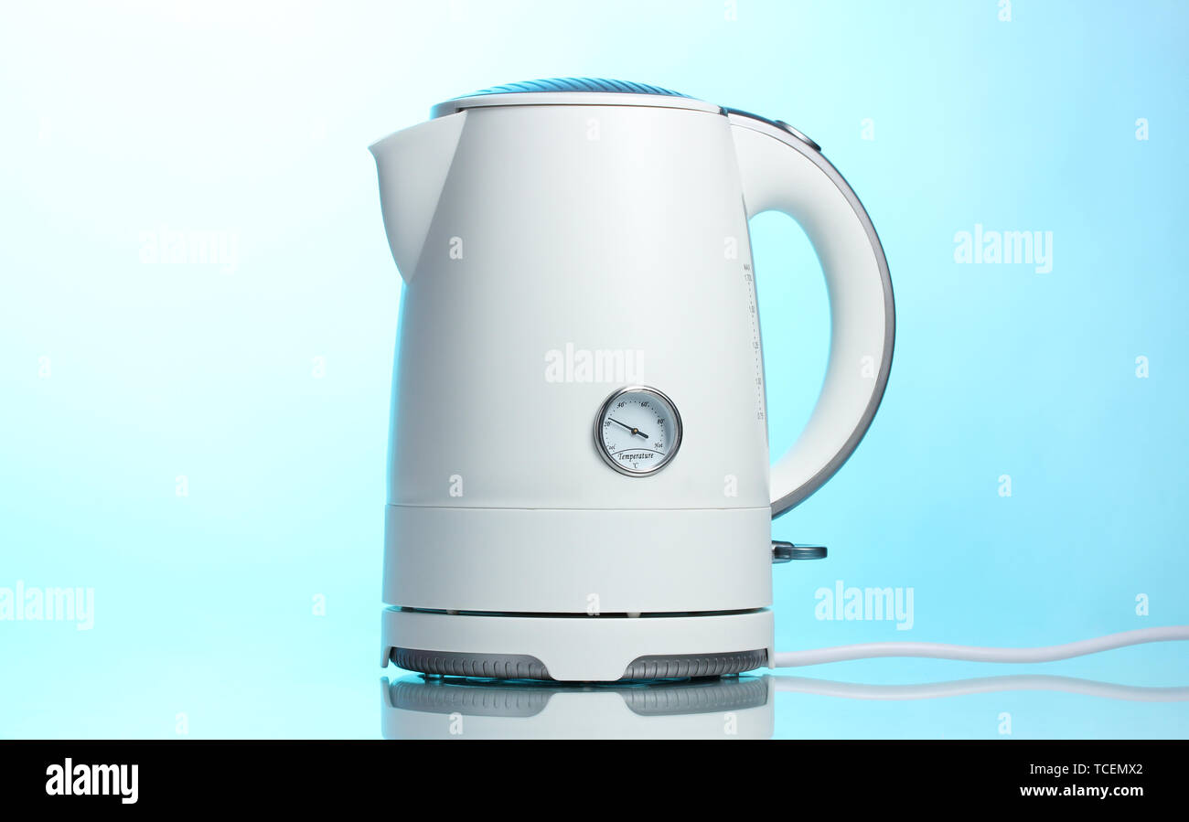 White electric kettle on blue Stock Photo - Alamy