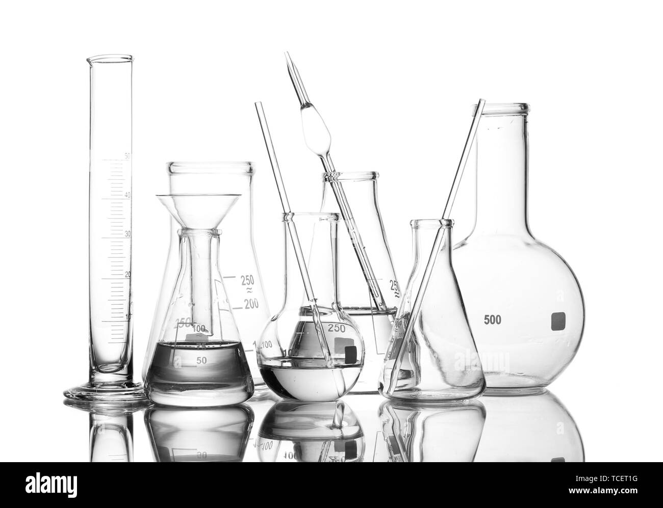 Different laboratory glassware with water and empty with reflection ...