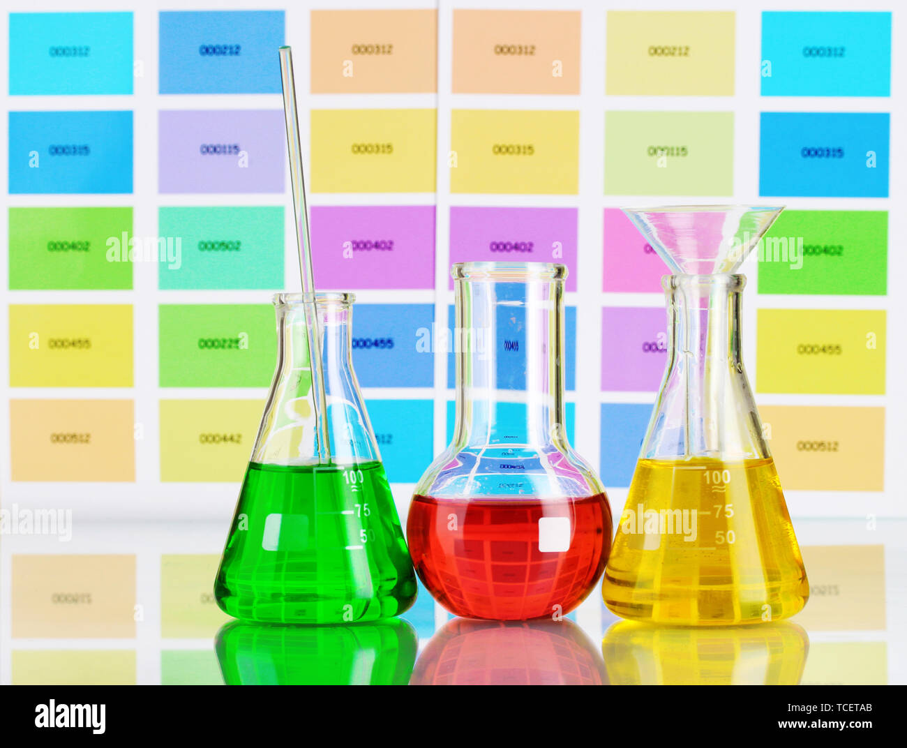 Three flasks with color liquid on color samples background Stock Photo ...