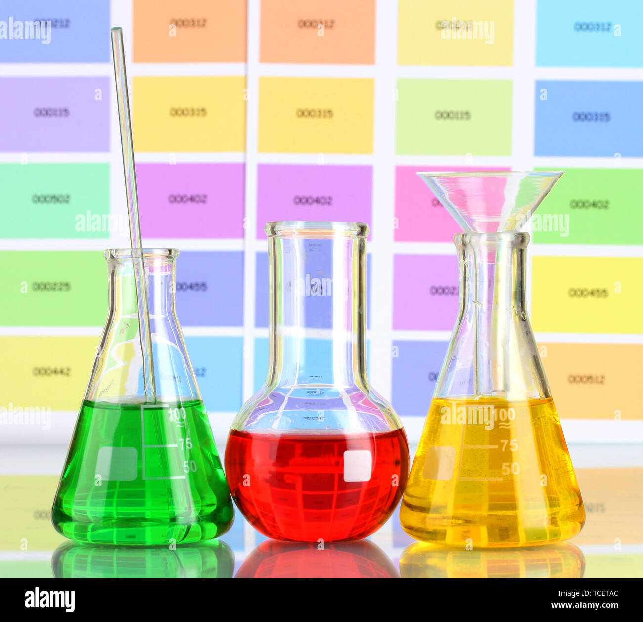 Three flasks with color liquid on color samples background Stock Photo ...