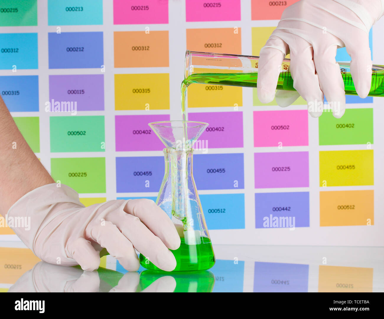 Laboratory flask and tube with green liquid in scientist's hands on ...