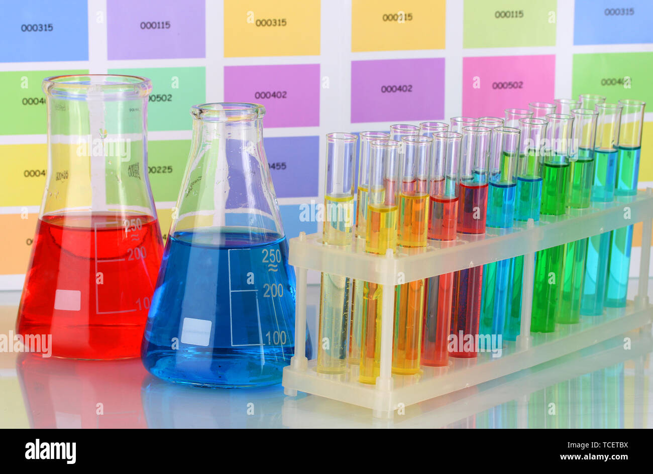 Test-tubes and flasks with color liquid on color samples background ...