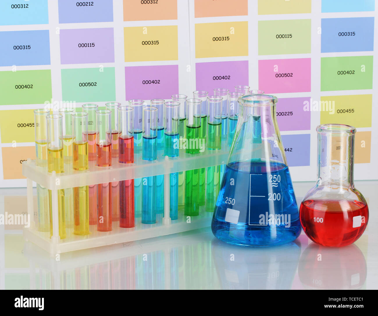 Test-tubes and flasks with color liquid on color samples background ...