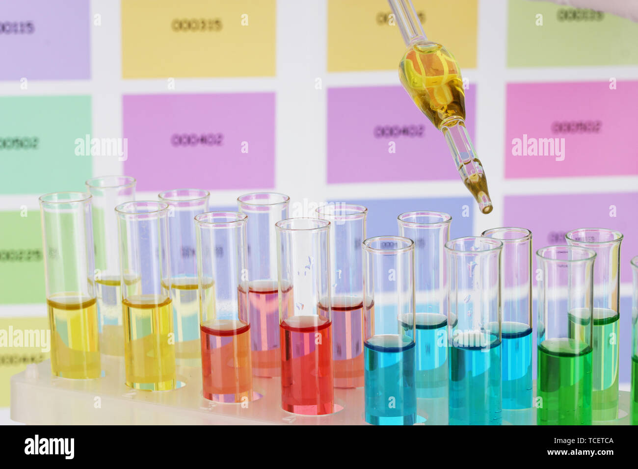 Test-tubes with color liquid and pipette on color samples background ...
