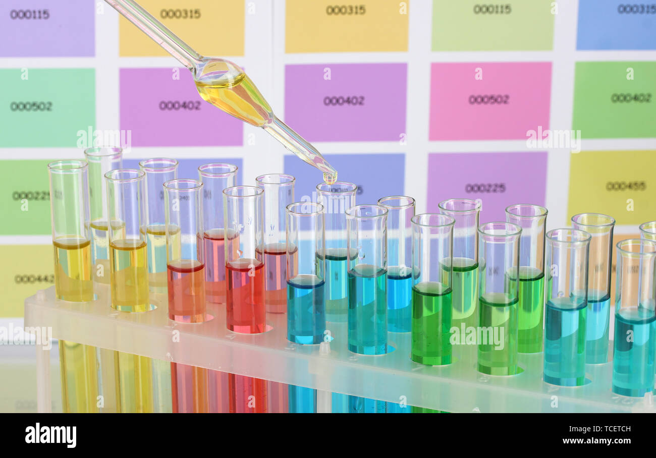 Test-tubes with color liquid and pipette on color samples background ...