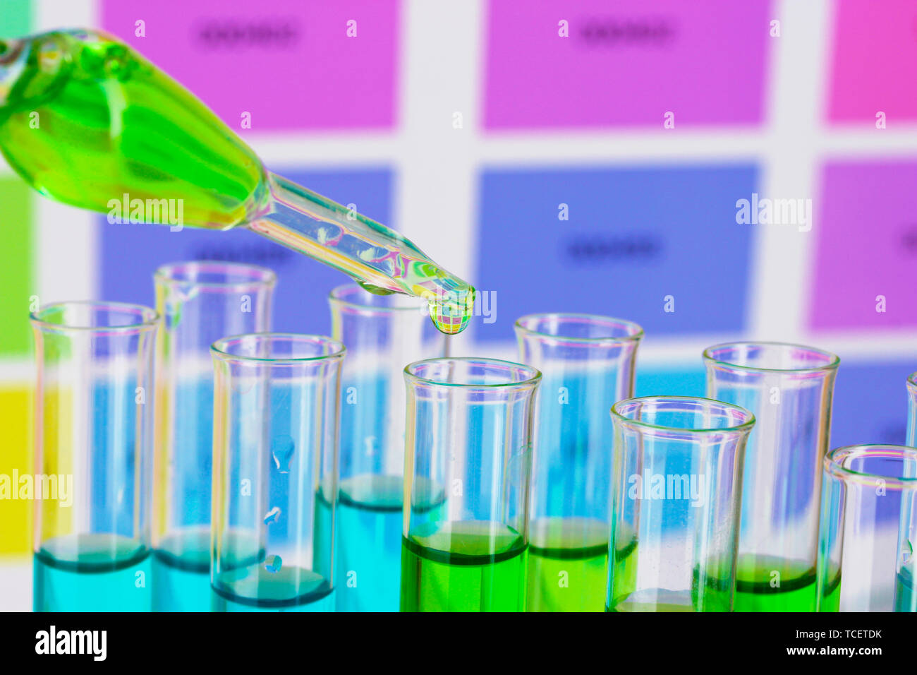 Test-tubes with color liquid and pipette on color samples background ...