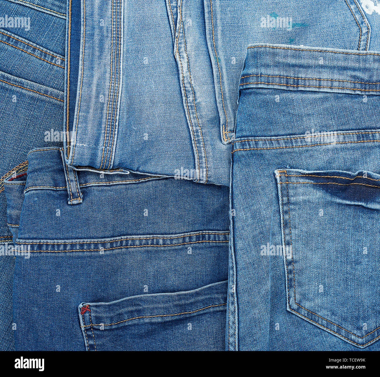 Lots of blue classic jeans stacked chaotically, back pocket, full frame ...