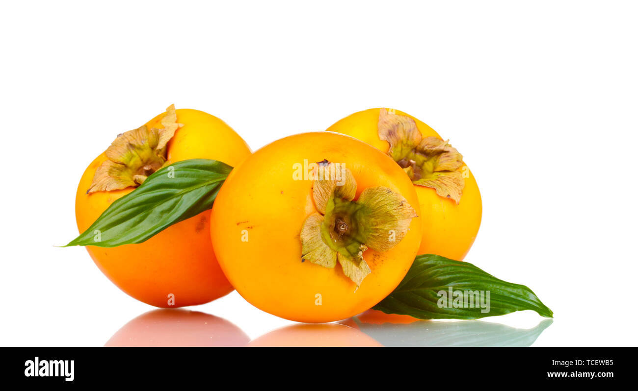 Three appetizing persimmons with green leaves isolated on white Stock ...