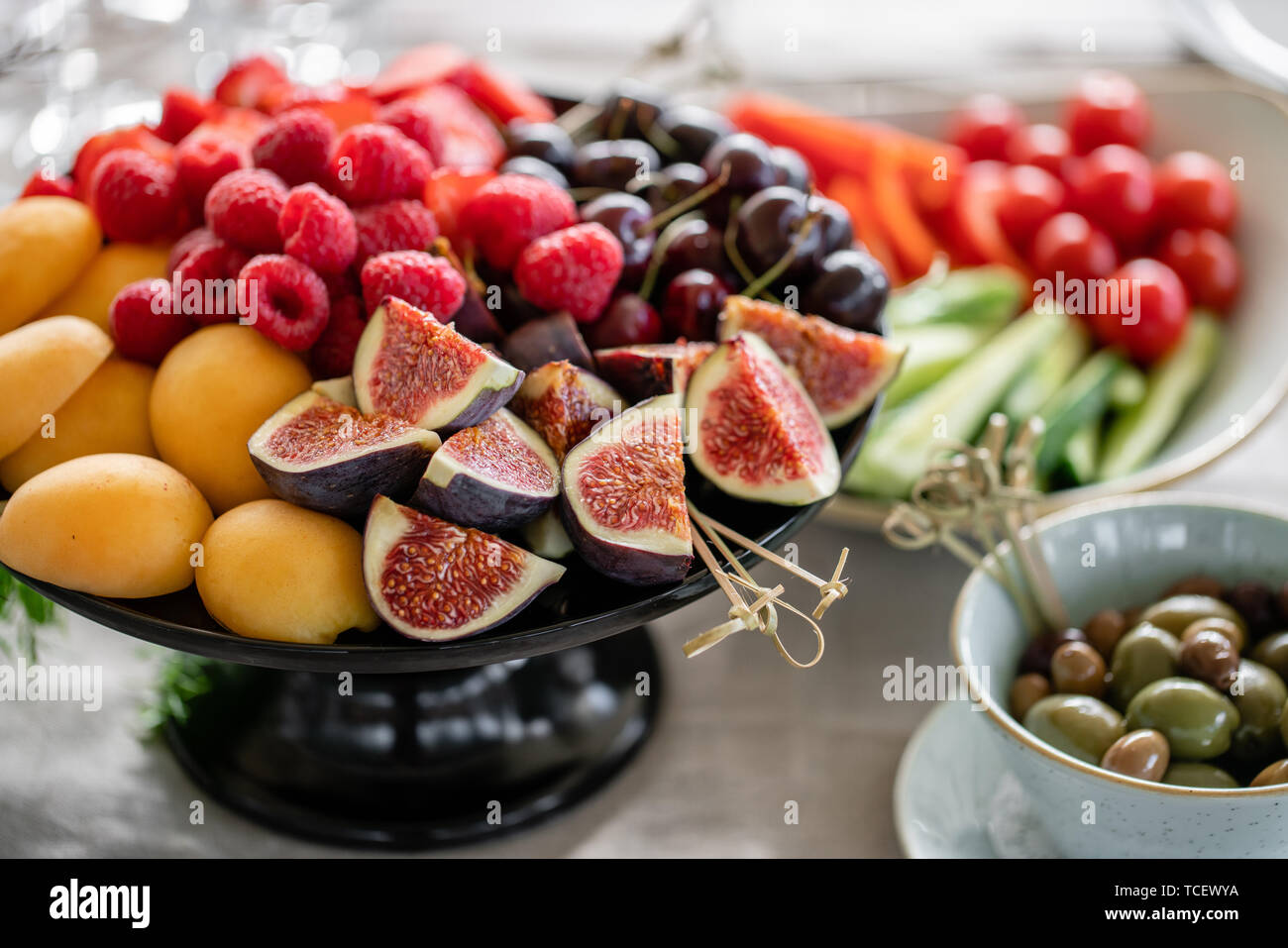Table with cold snacks and tableware. Fresh Fruit platter on banquet ...