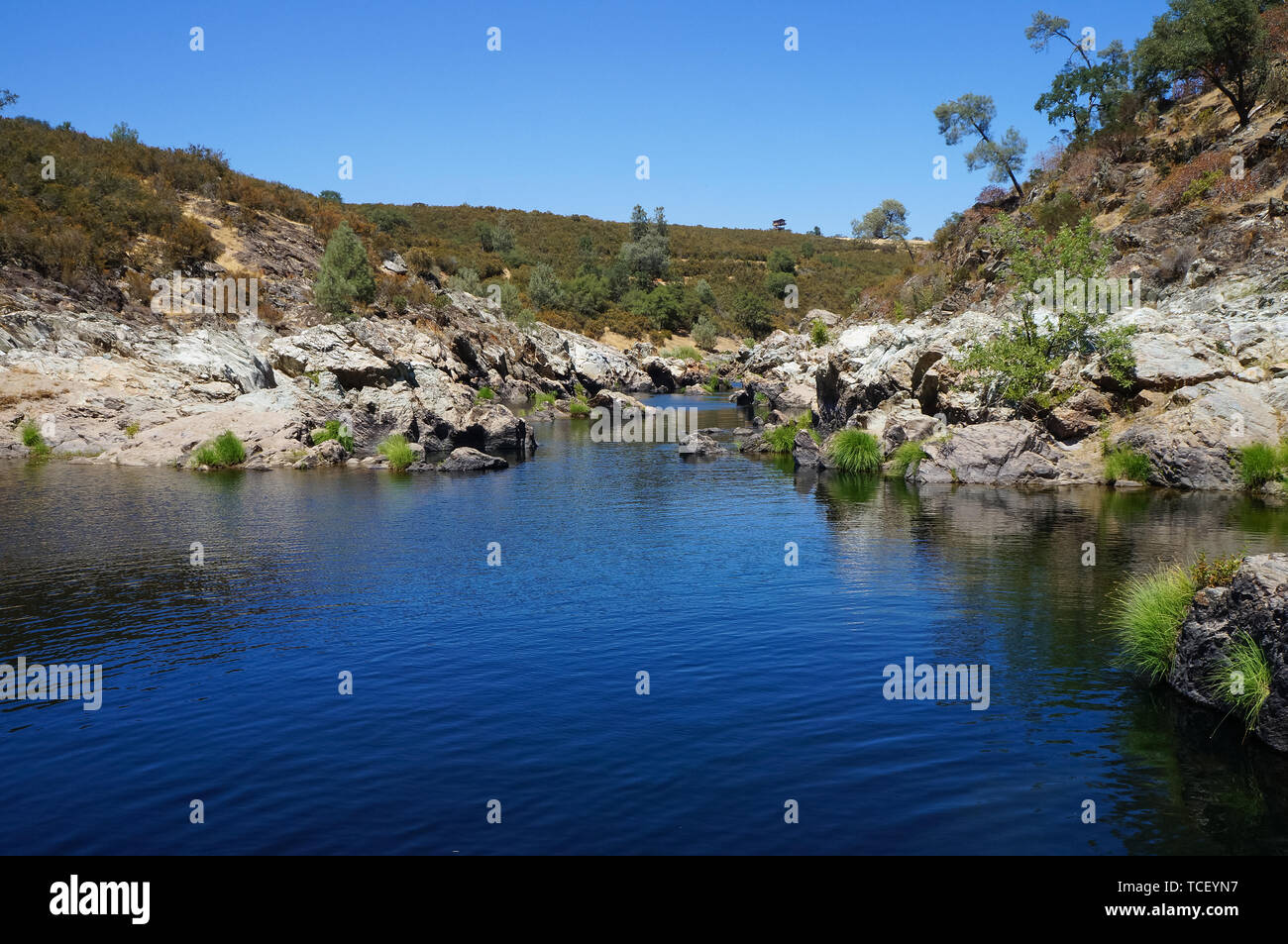 Blue water river rocks trees, landscape Stock Photo - Alamy