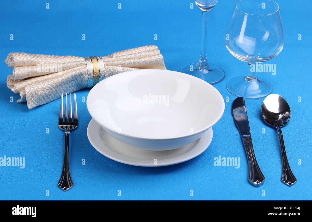 Table setting on blue background Stock Photo - Alamy