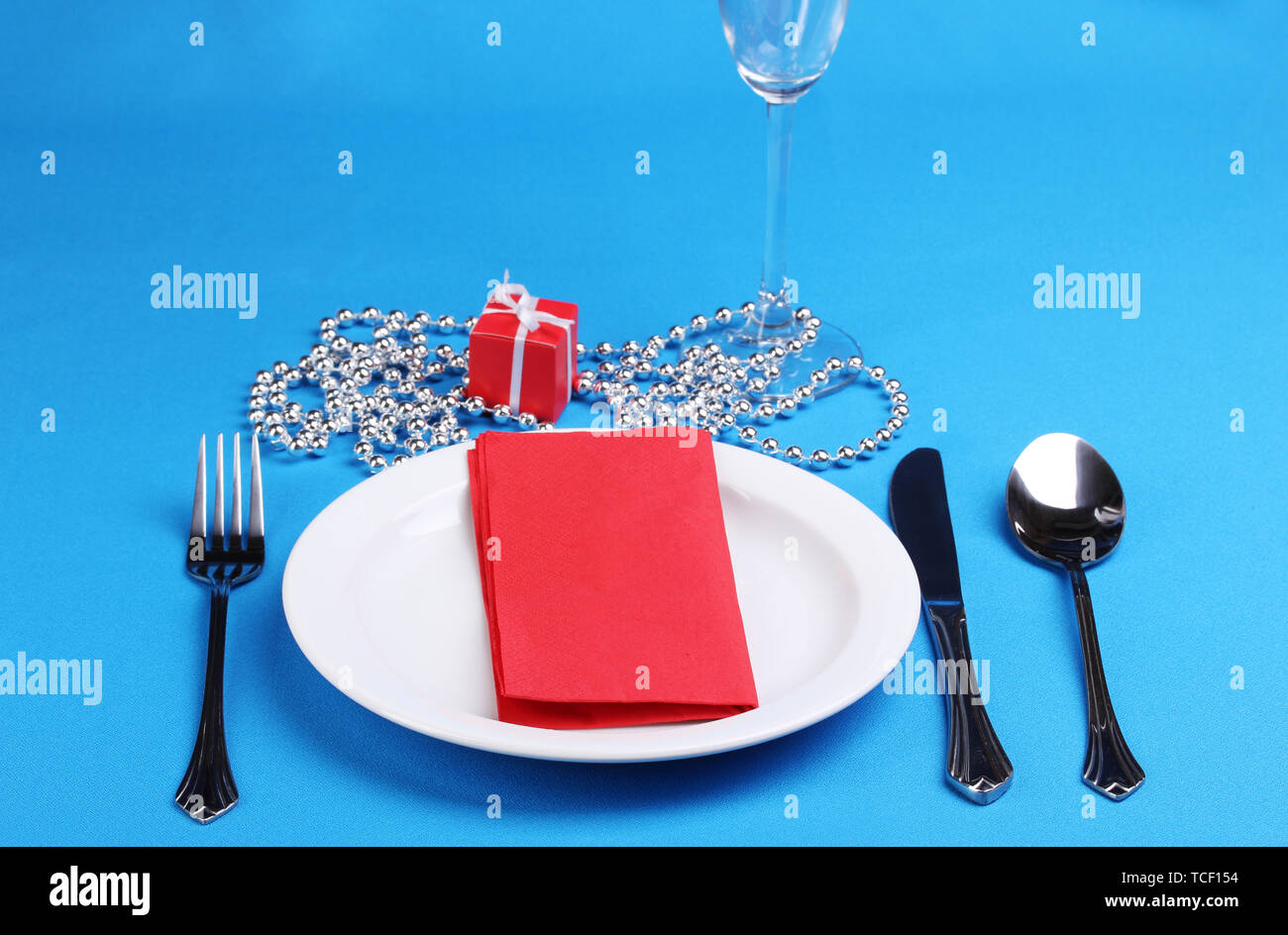 Table setting on blue background Stock Photo - Alamy