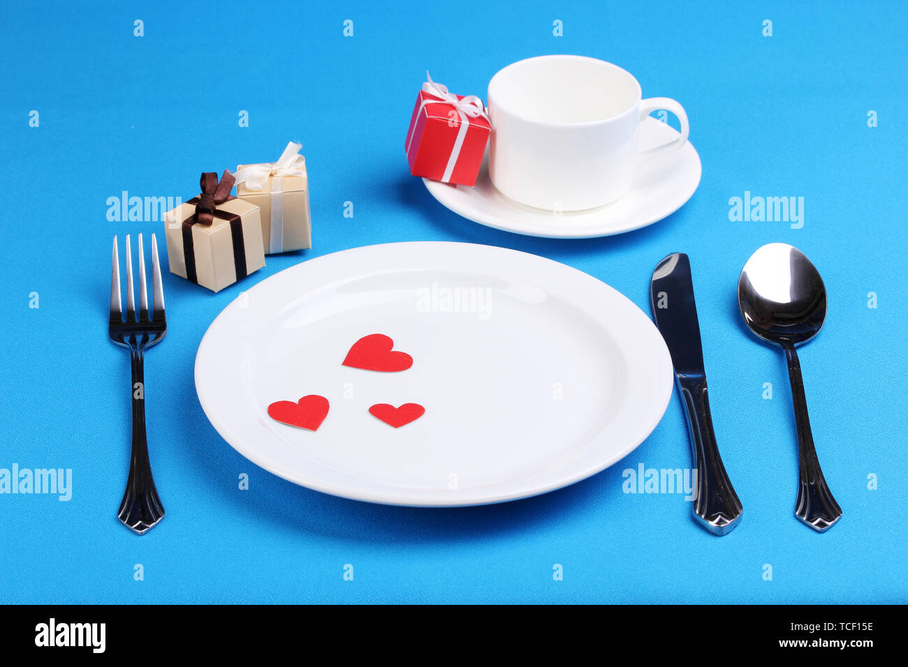 Table setting on blue background Stock Photo - Alamy