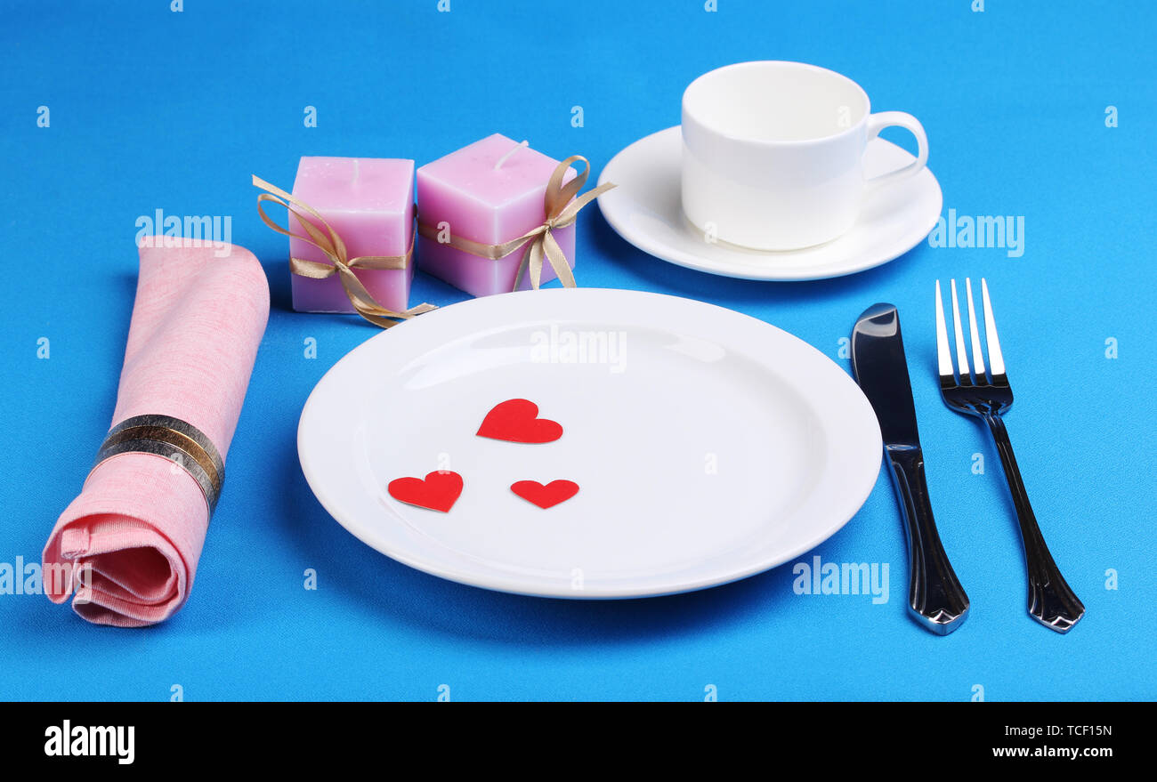 Table setting on blue background Stock Photo - Alamy