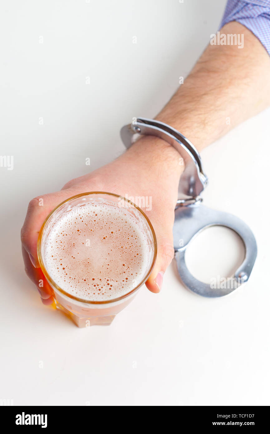 Glass of beer with handcuffs as symbol for alcohol abuse Stock Photo ...