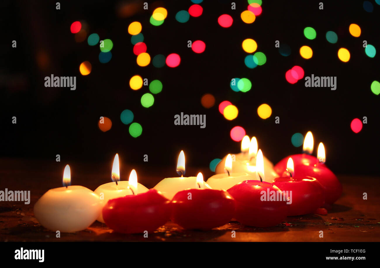 Beautiful candles on wooden table on bright background Stock Photo - Alamy