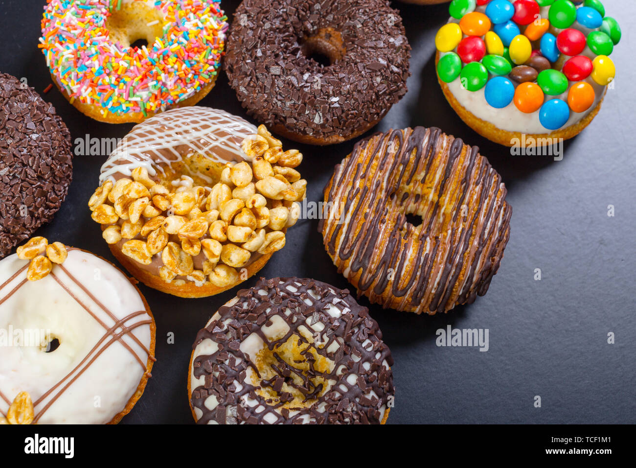 Assorted donuts from above on black background Stock Photo - Alamy