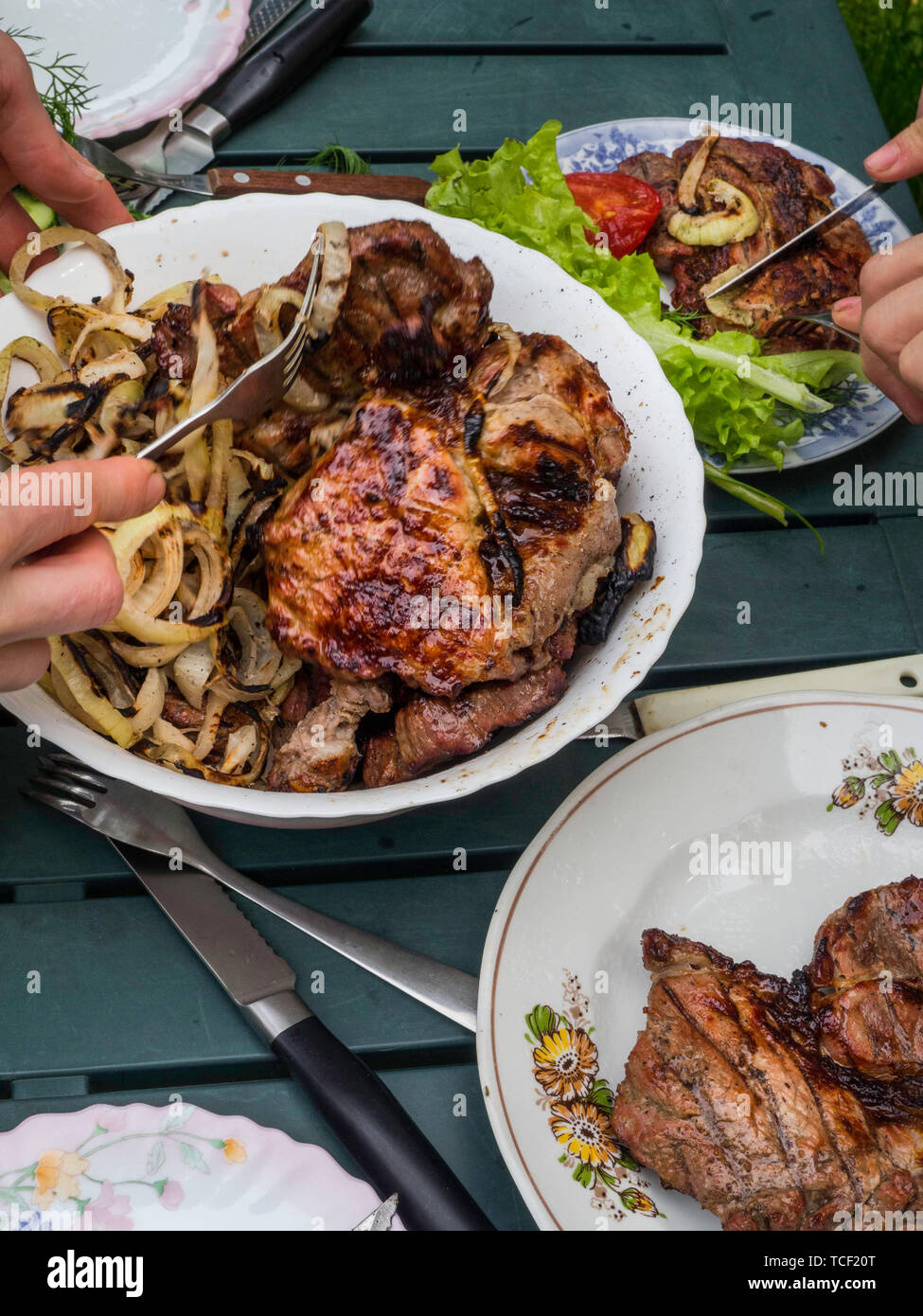 people hand cut bbq with knife, eating healthy fresh salad and barbecue ...