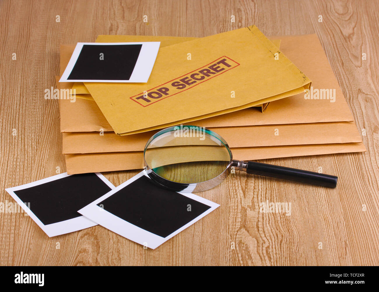 Envelopes with top secret stamp with photo papers and magnifying glass ...