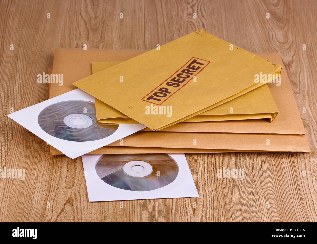 Envelopes with top secret stamp with CD disks on wooden background ...
