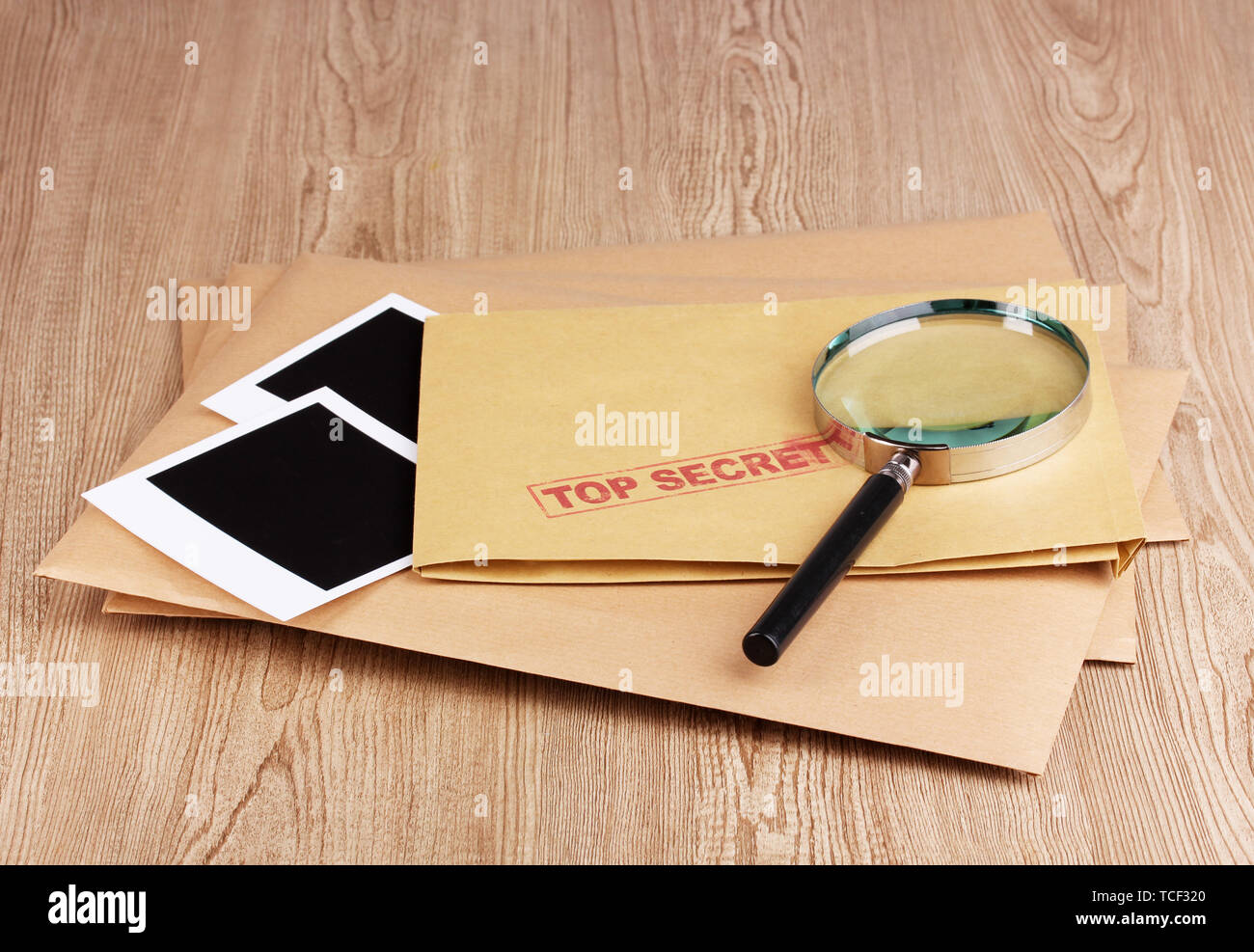 Envelopes with top secret stamp with photo papers and magnifying glass ...