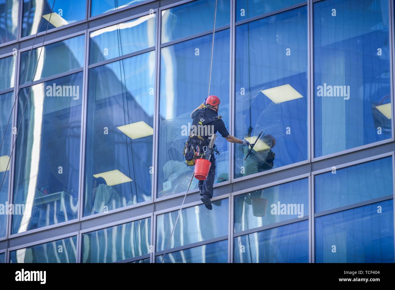 Window cleaner on glass facade of a high-rise building, Financial ...