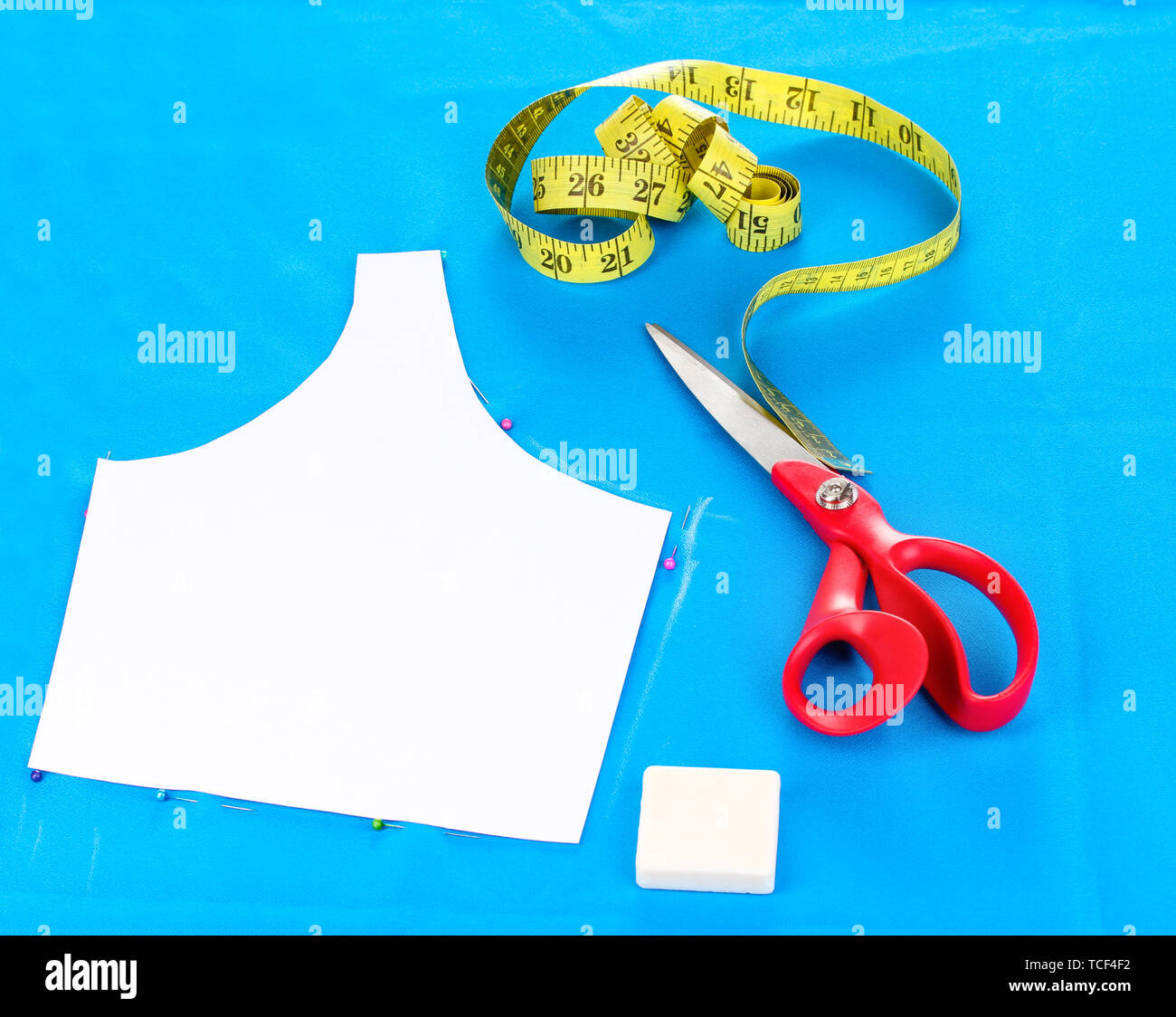 Scissors, measuring tape and pattern on fabric isolated on white Stock ...