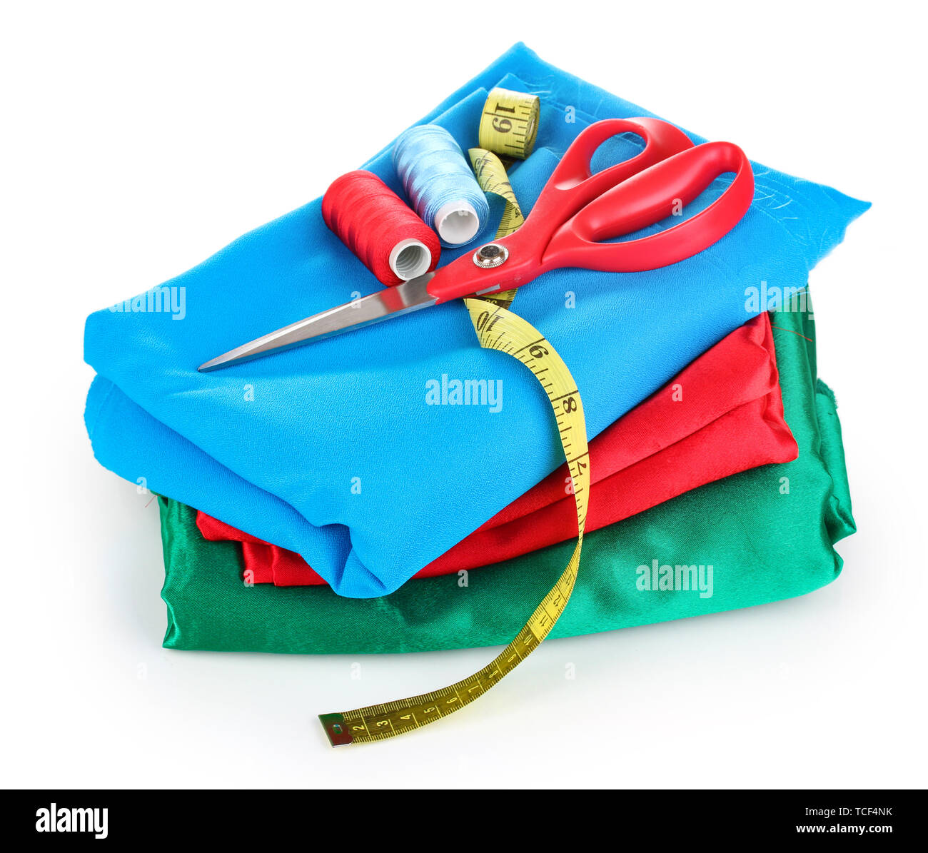 Scissors, bright thread and measuring tape on fabric isolated on white ...