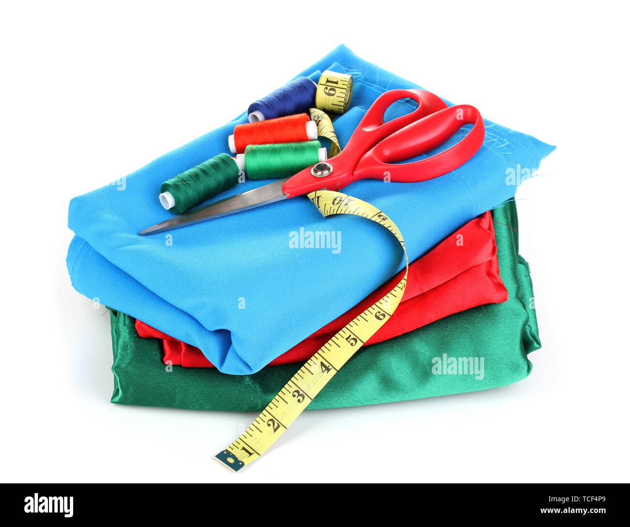 Scissors, bright thread and measuring tape on fabric isolated on white ...