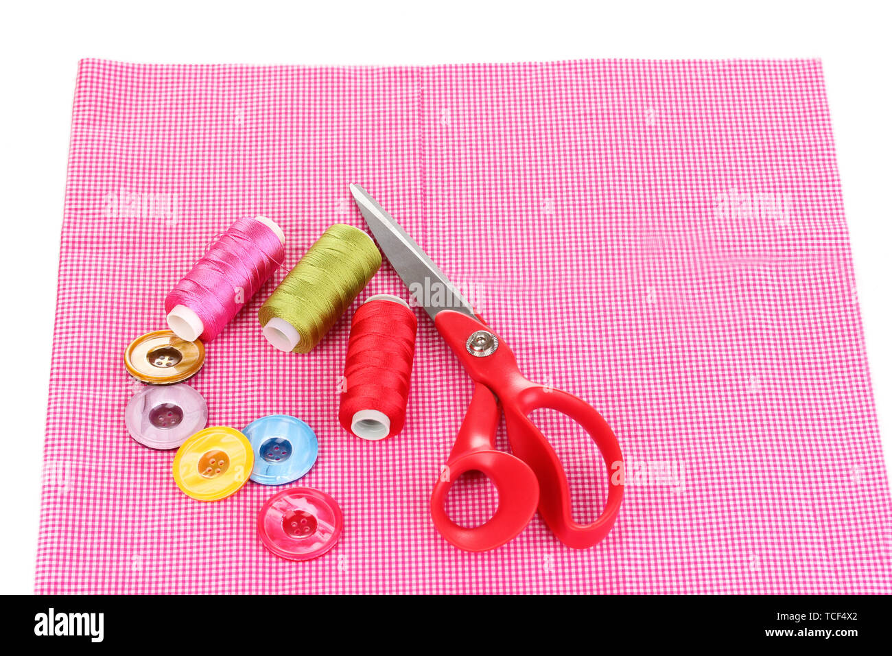 Scissors, buttons and bright threads on fabric isolated on white Stock ...