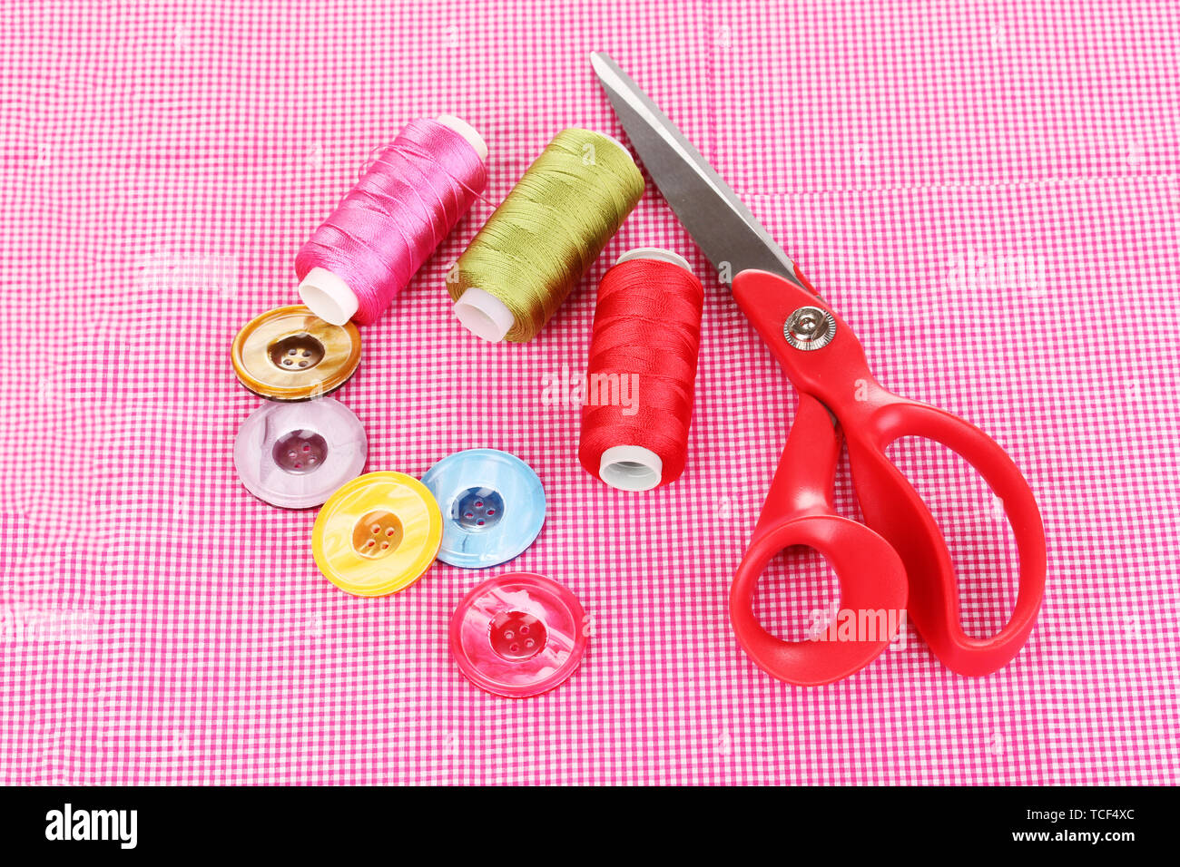Scissors, buttons and bright threads on fabric isolated on white Stock ...
