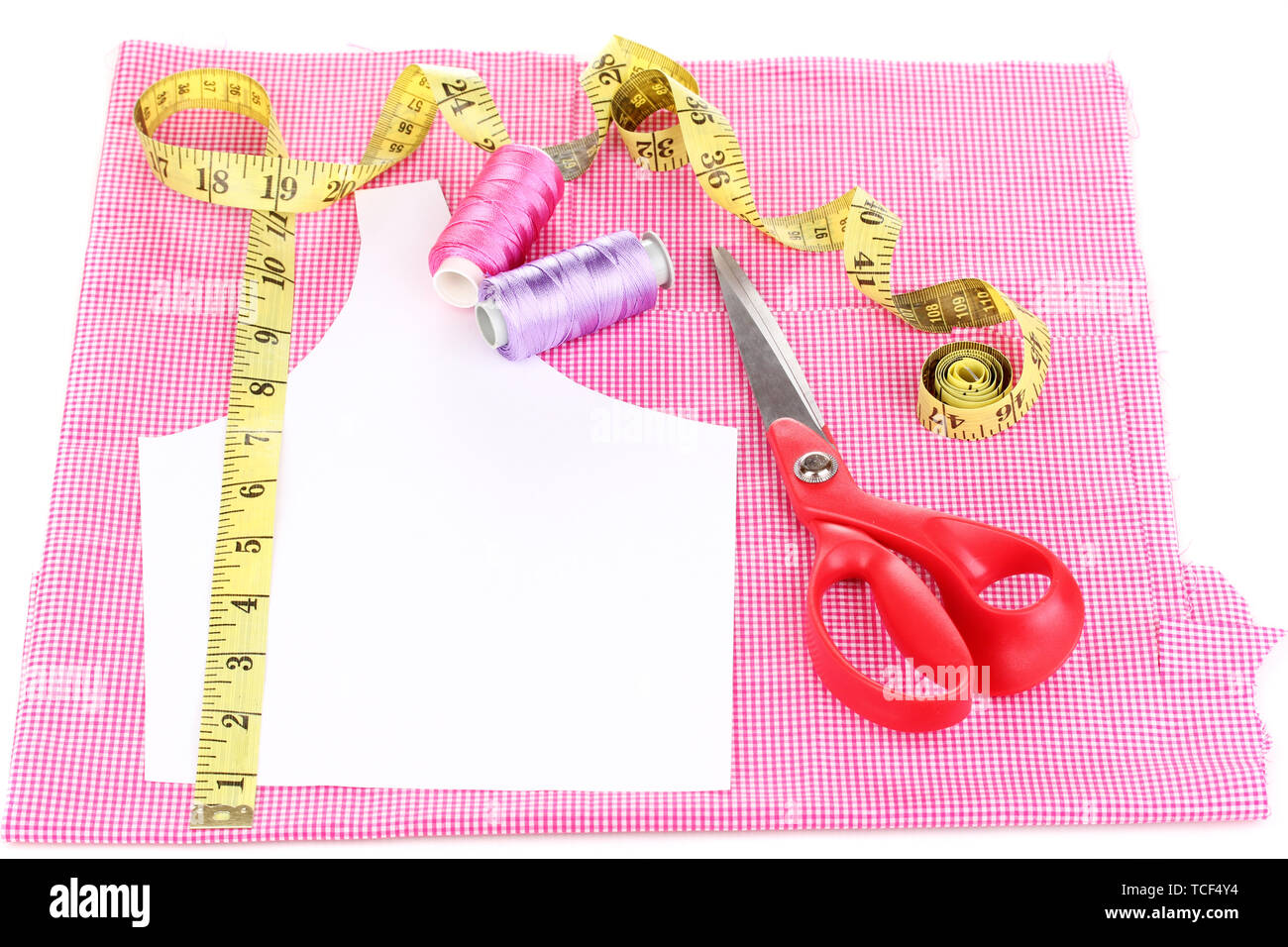 Scissors,threads, measuring tape and pattern on fabric isolated on ...