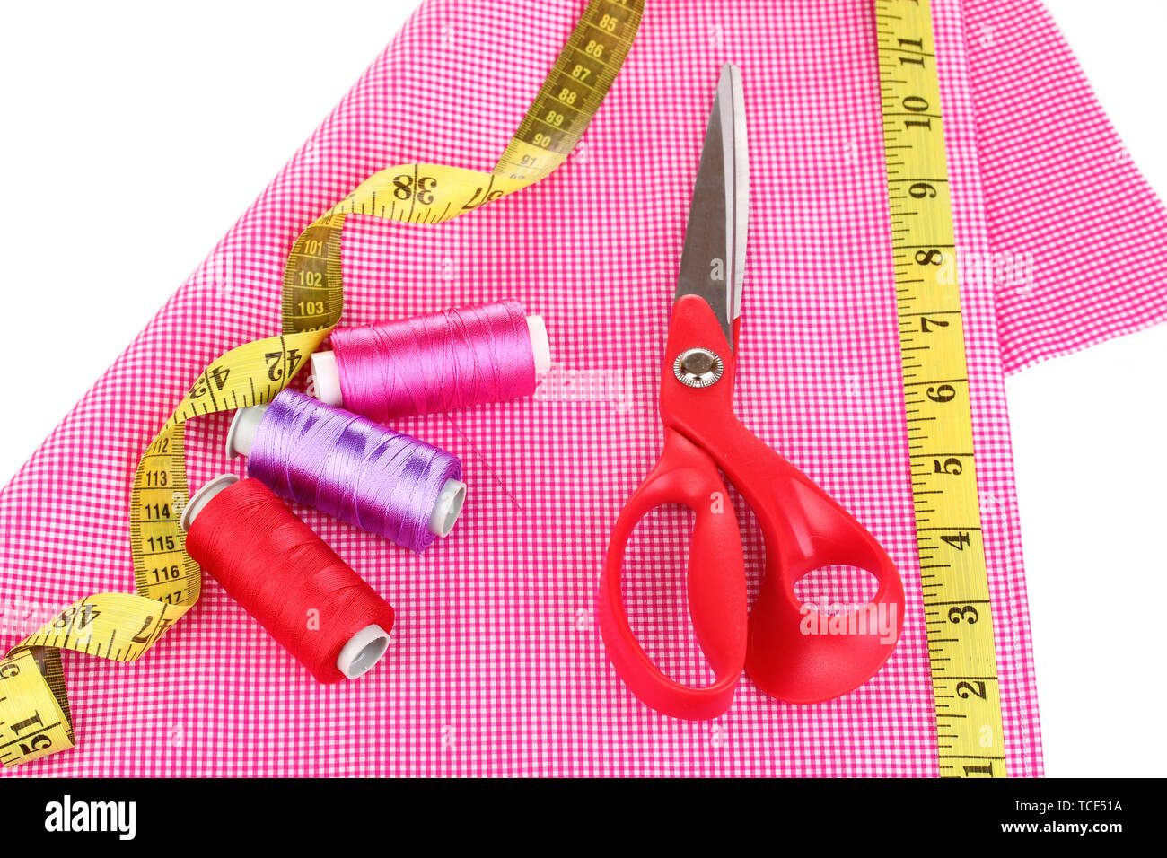 Scissors,threads, measuring tape and pattern on fabric isolated on ...