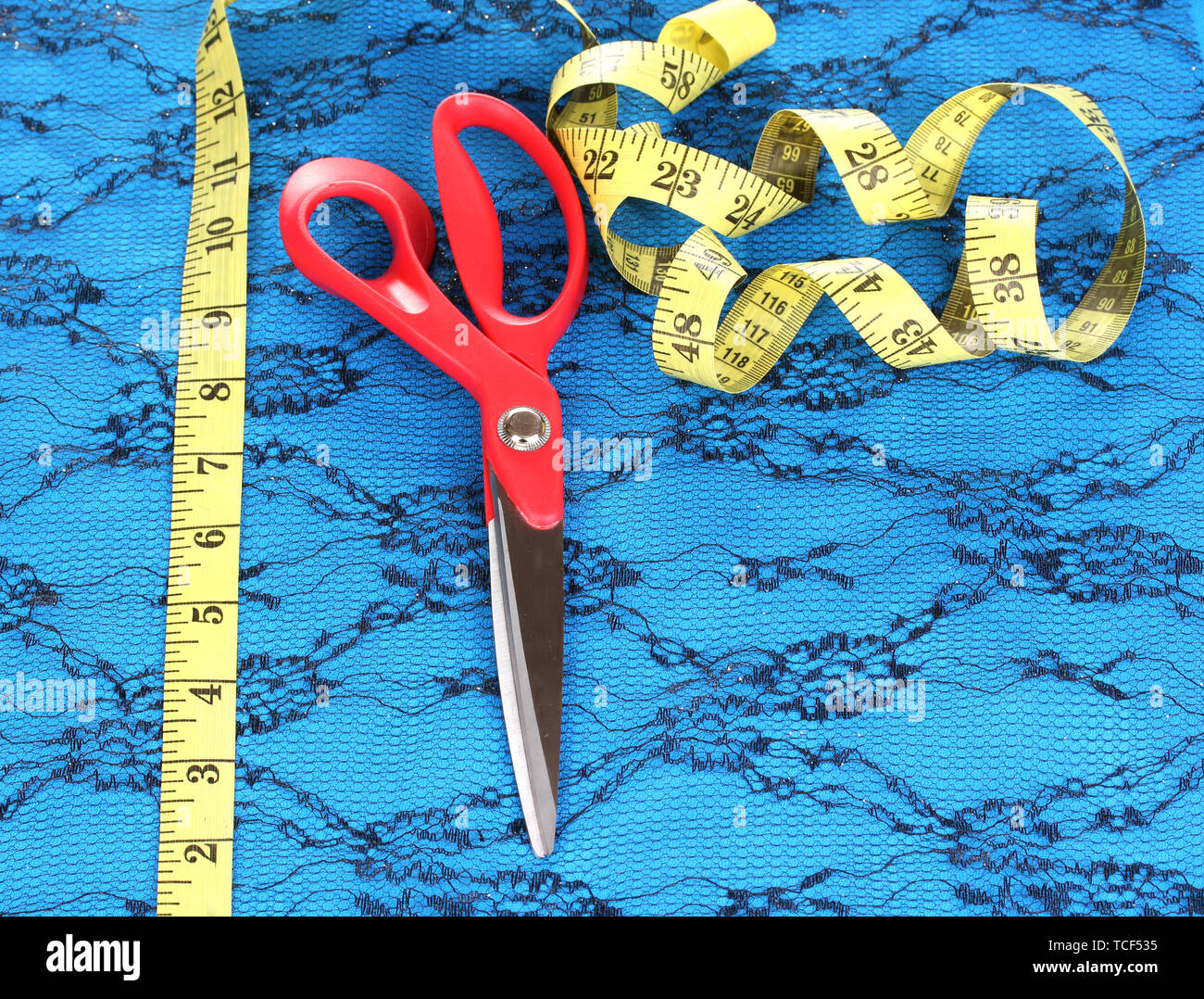 Scissors, measuring tape and pattern on fabric isolated on white Stock ...