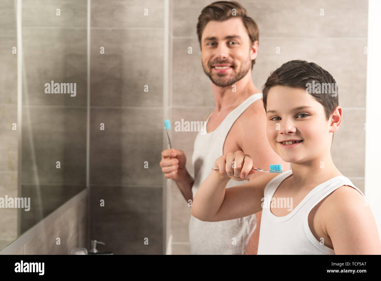 Kid brushing teeth with dad hi-res stock photography and images - Alamy