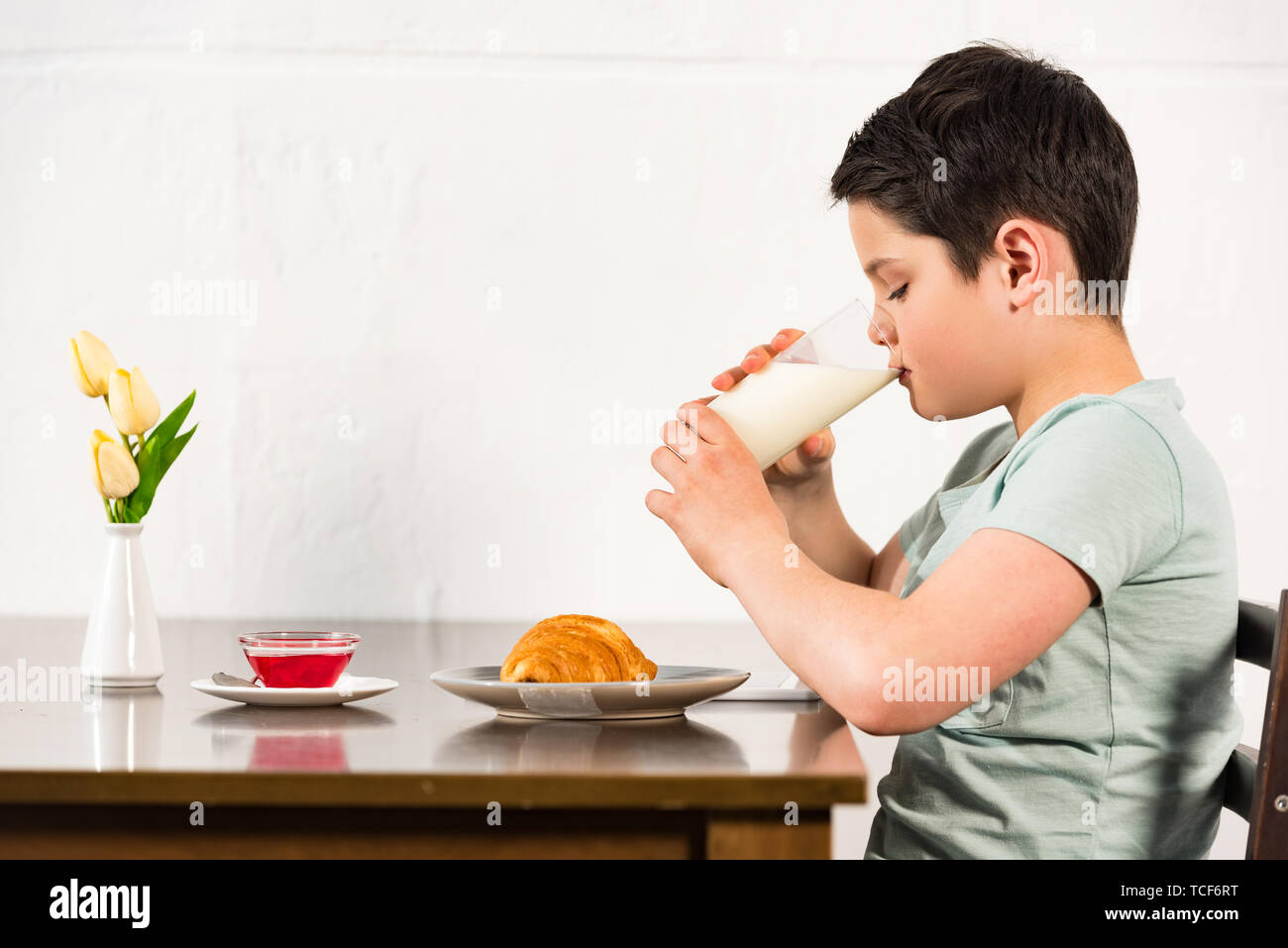 side view of boy drinking milk during breakfast Stock Photo - Alamy