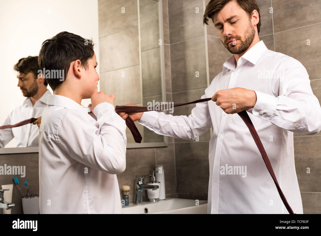 father and son dressing in formal wear in bathroom Stock Photo - Alamy
