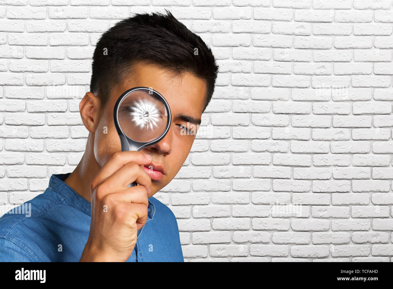 portrait of a young man looking through a magnifying glass Stock Photo ...