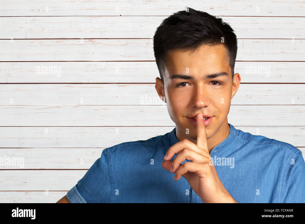 serious young man making hush sign Stock Photo - Alamy