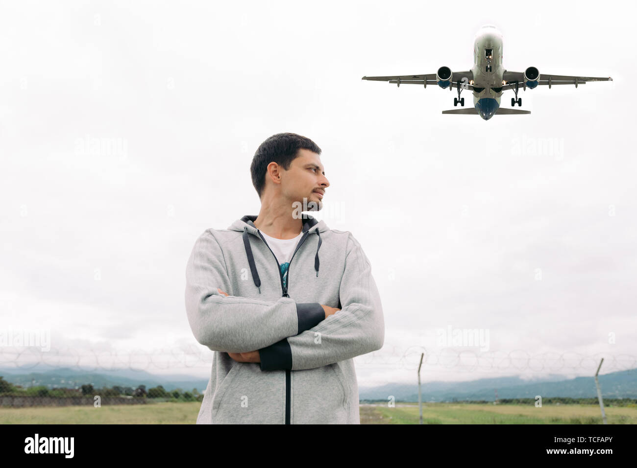 traveler man stands and looks the airplane taking off Stock Photo - Alamy