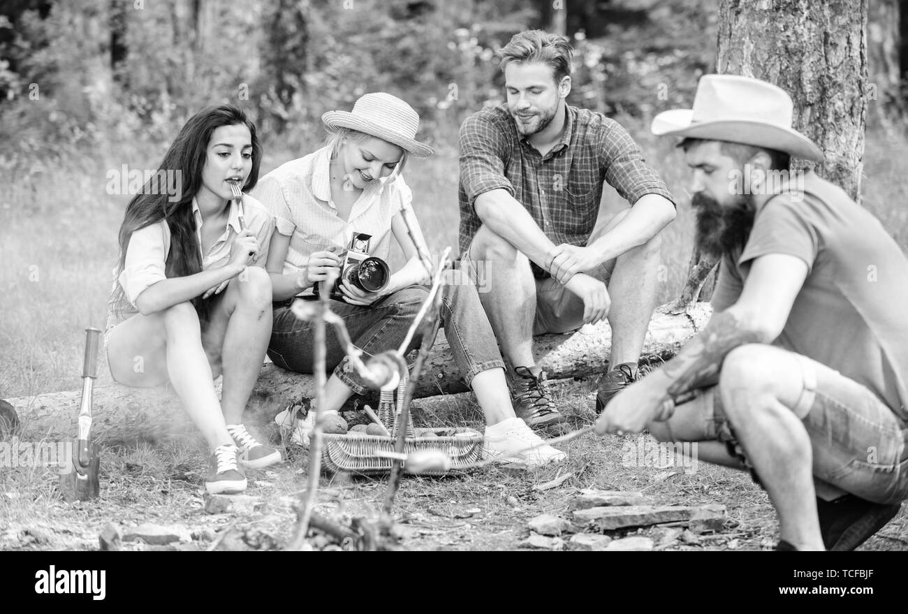 Tourists having snack time with roasted over fire food. Friends group ...