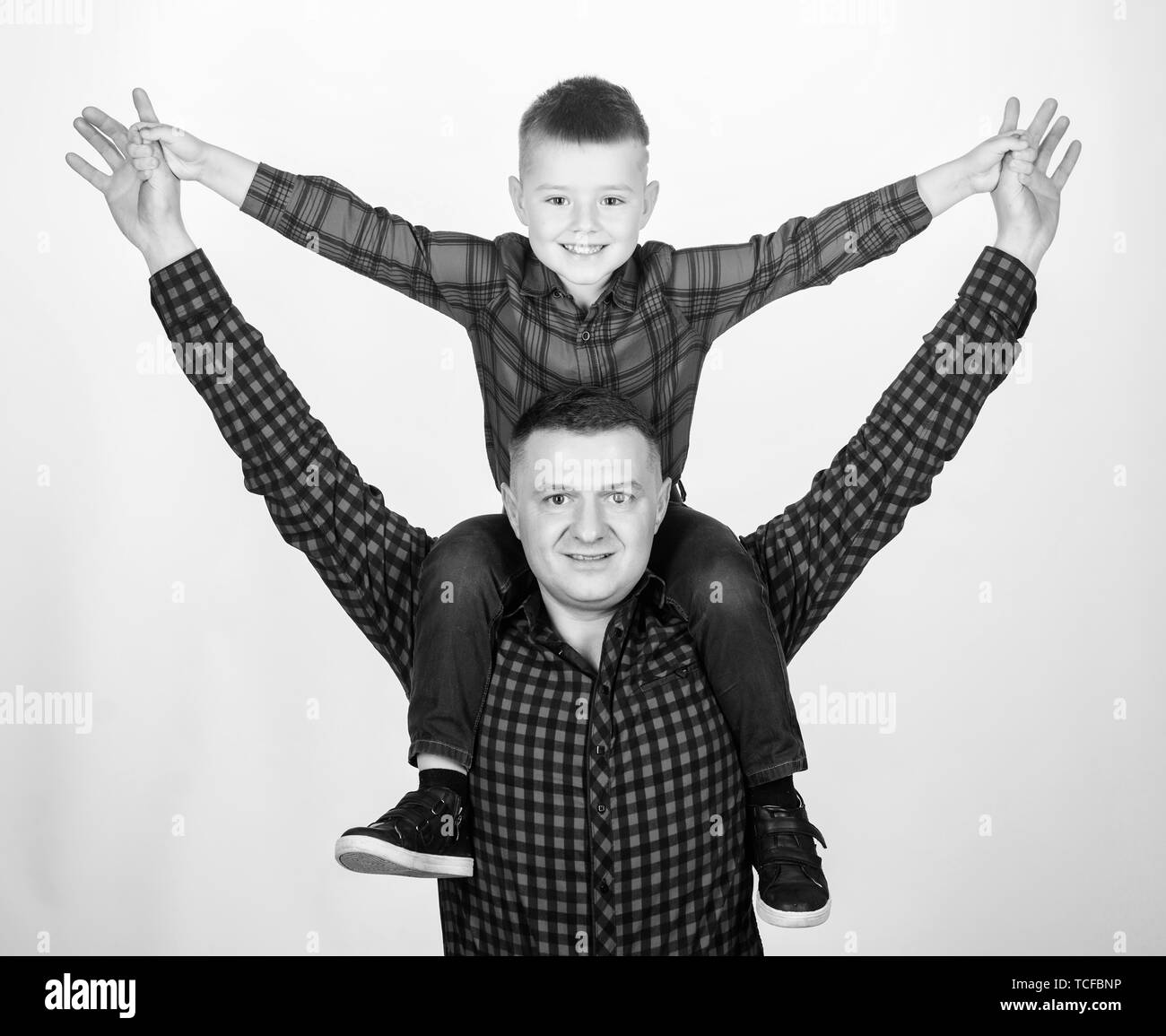 Father little son red shirts family look outfit. Child riding on dads ...