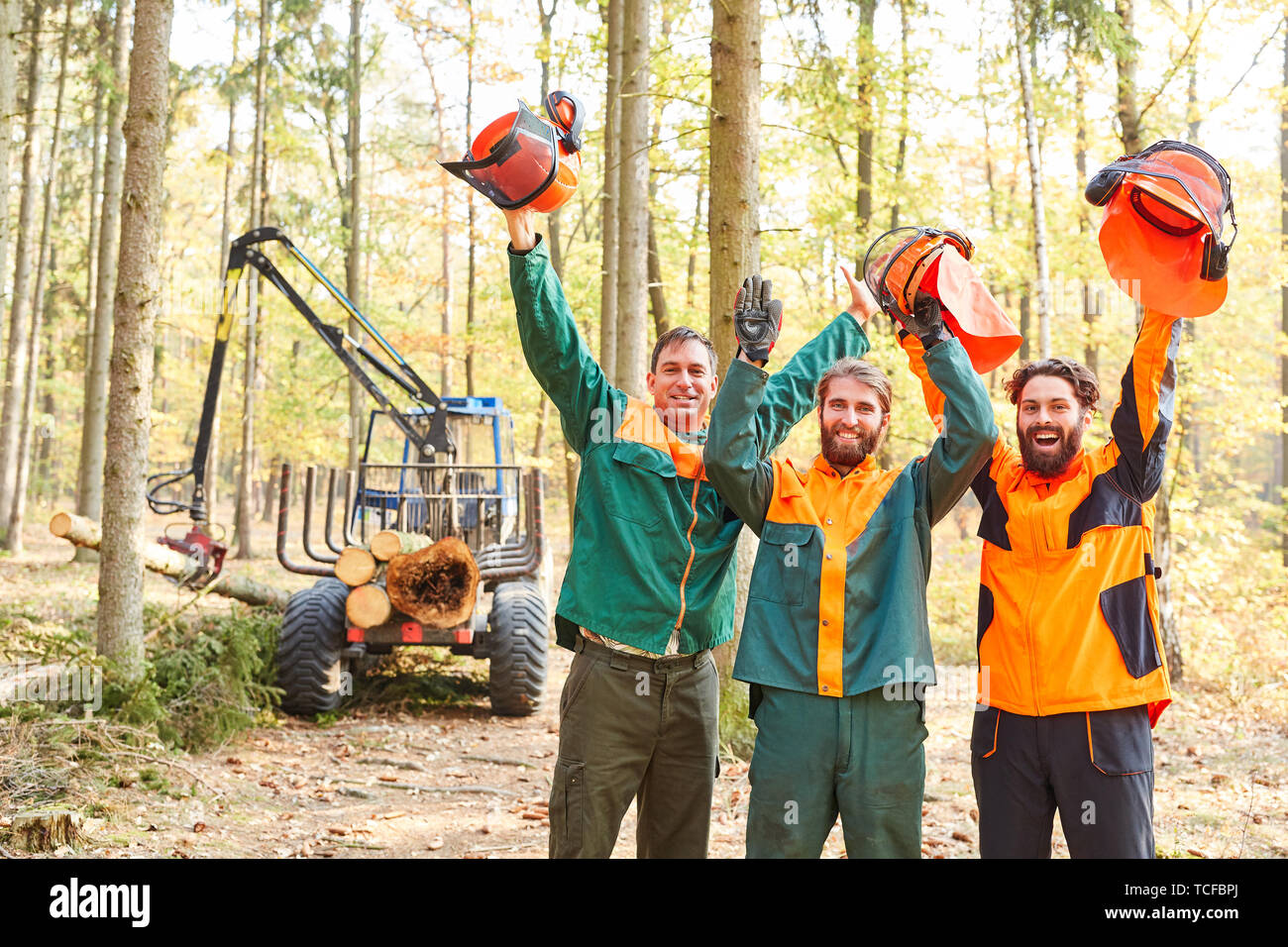 Successful lumberjack team celebrates with wooden helmets in their ...