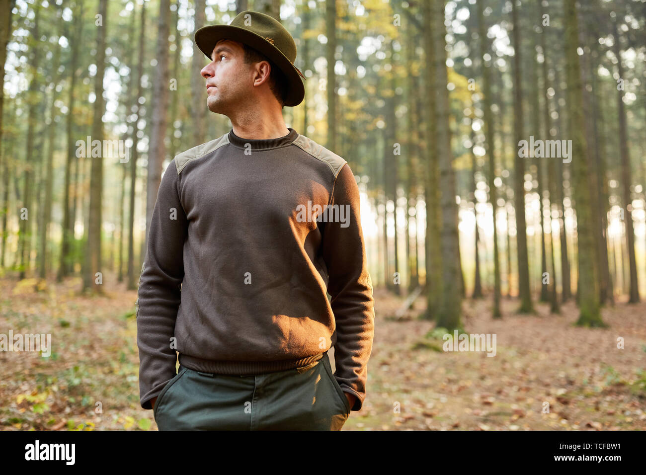 Man stands as a forest ranger or forestry in the forest in front of ...