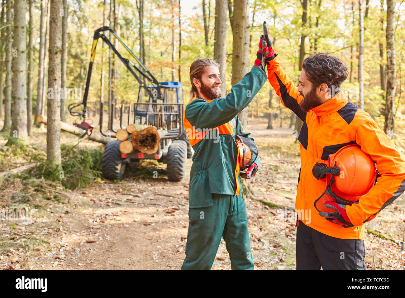 Two lumberjacks give themselves a high five to motivation in the wood ...