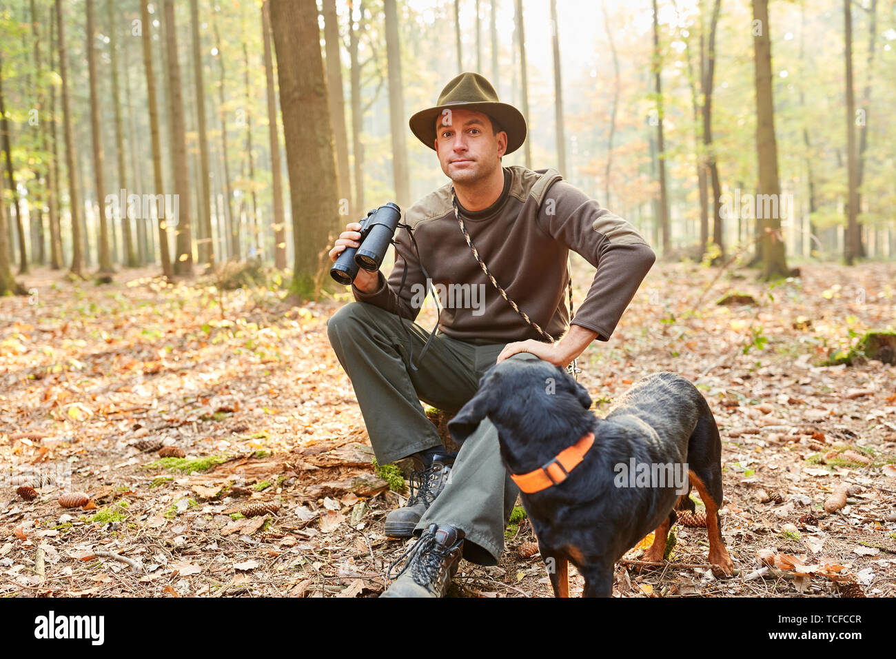 Forester or hunter with a hound as a hunting dog and binoculars in the ...