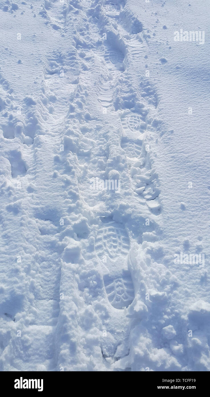 Footsteps on the snow background Stock Photo - Alamy