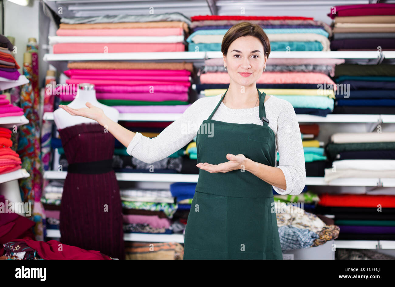 Female shop assistant demonstrating assortment at drapery shop Stock ...